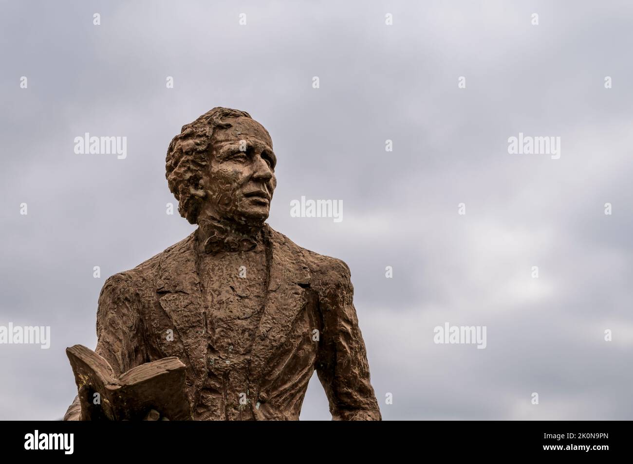 Bronze statue of the danish poet H C Andersen standing against a bright ...