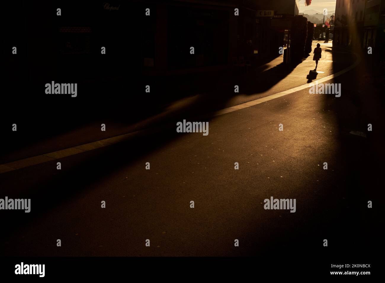 Anonymous woman walking on street in bright sunlight Stock Photo - Alamy