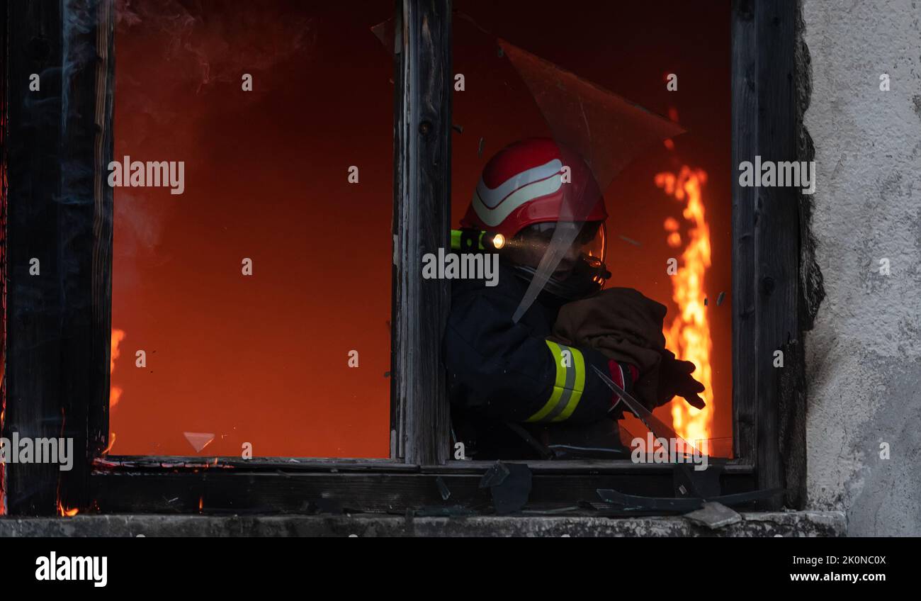 Firefighter hero carrying baby girl out from burning building area from ...