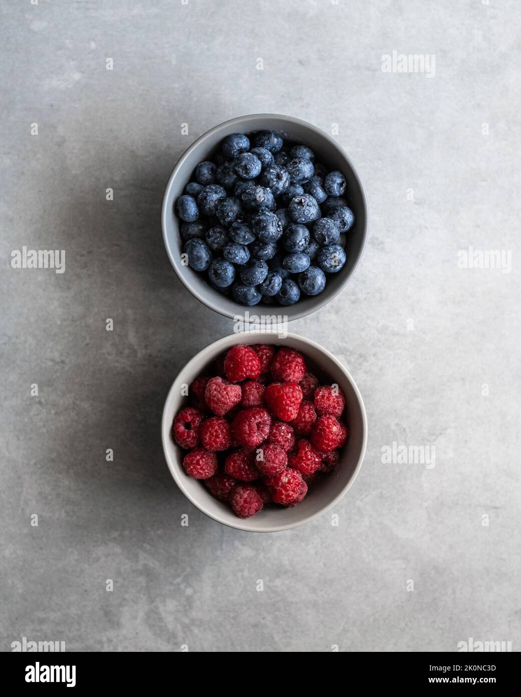 Two plates with blueberries and raspberries in a minimalist style Stock ...