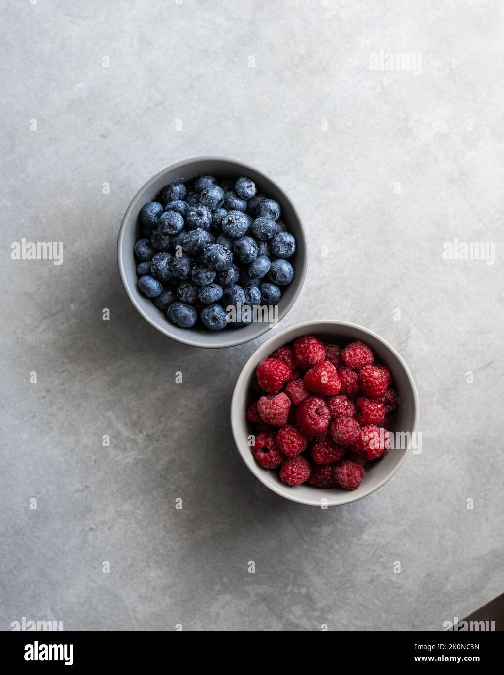 Two plates with blueberries and raspberries in a minimalist style Stock ...