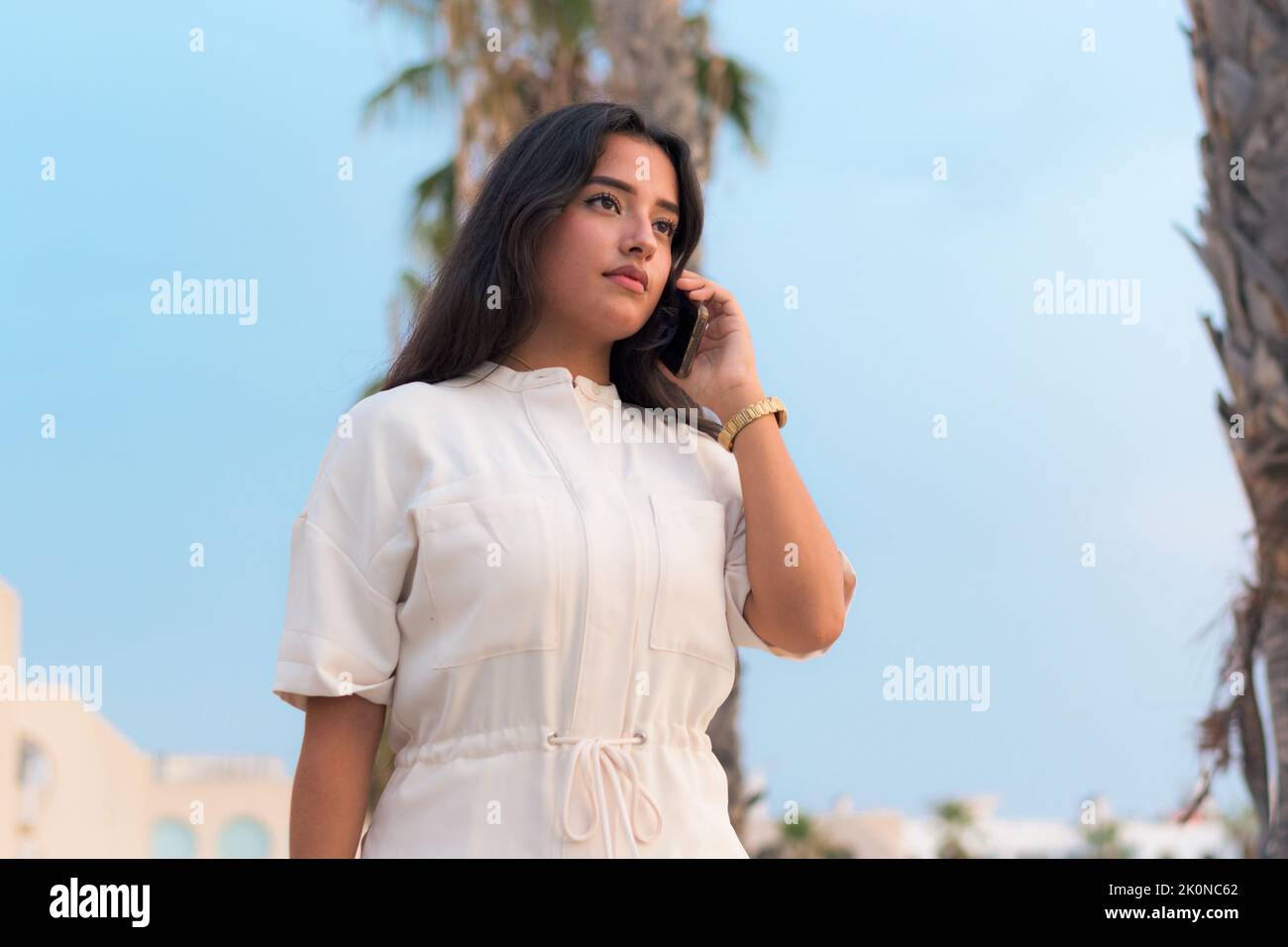 Business young Latin woman speaks through his mobile phone outside Stock Photo - Alamy