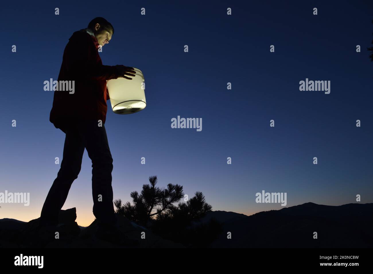 Man carrying a bucket of light Stock Photo - Alamy