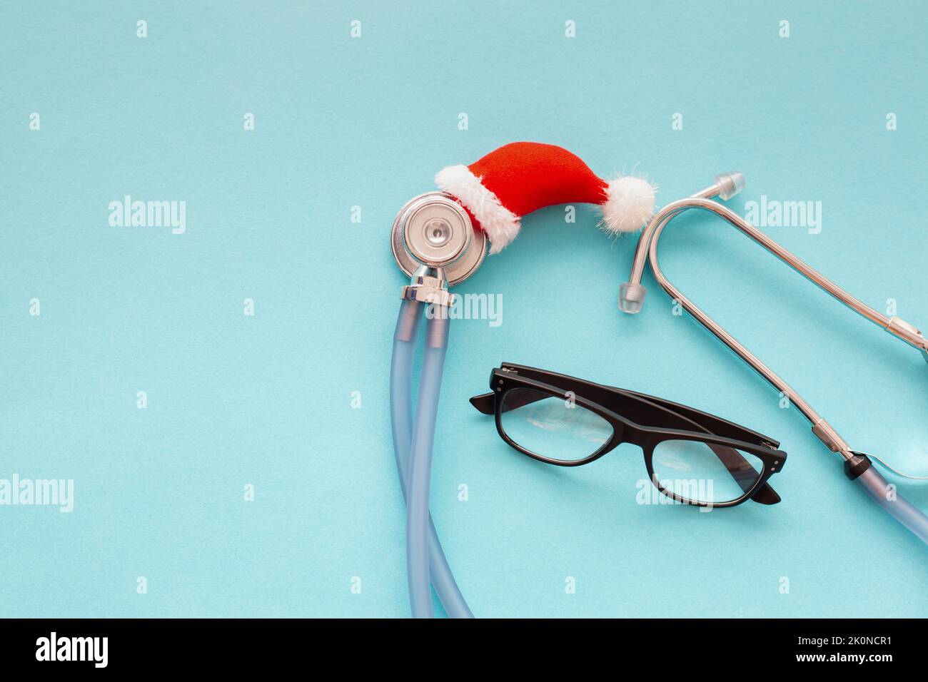 Medical stethoscope in a red Santa hat with glasses for vision on a ...