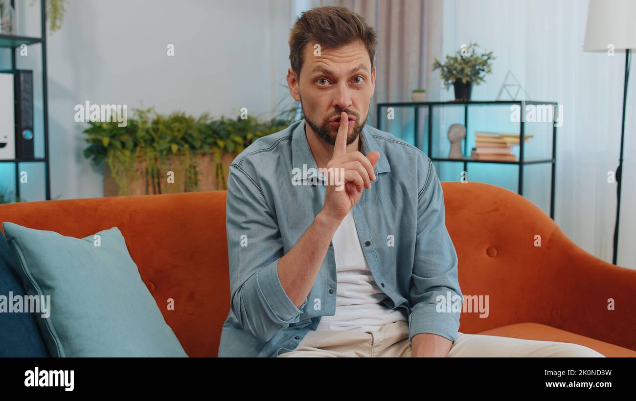 Shh be quiet please. Adult caucasian man presses index finger to lips ...