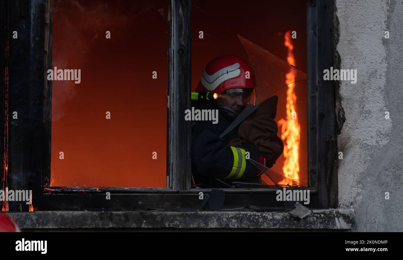 Firefighter hero carrying baby girl out from burning building area from ...