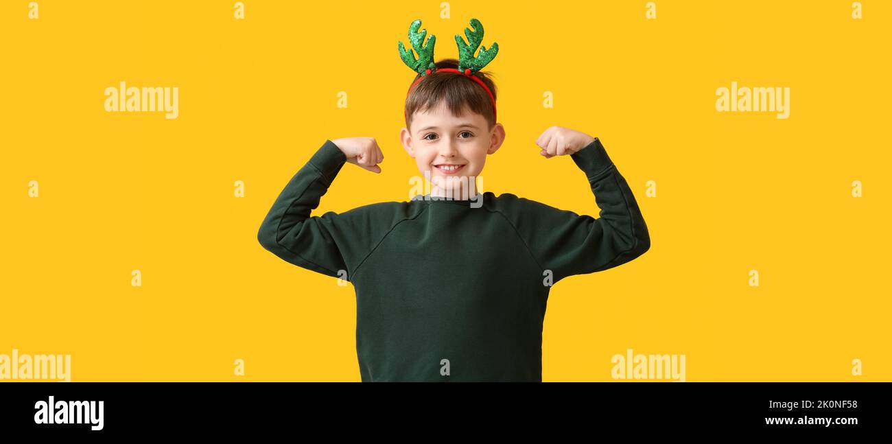 Funny little boy with reindeer horns on yellow background Stock Photo ...