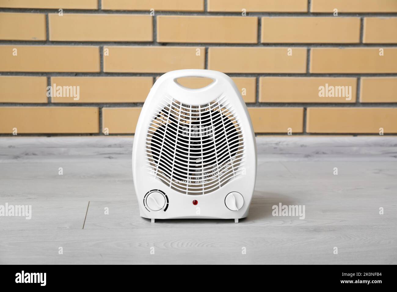 Electric fan heater near brick wall Stock Photo - Alamy