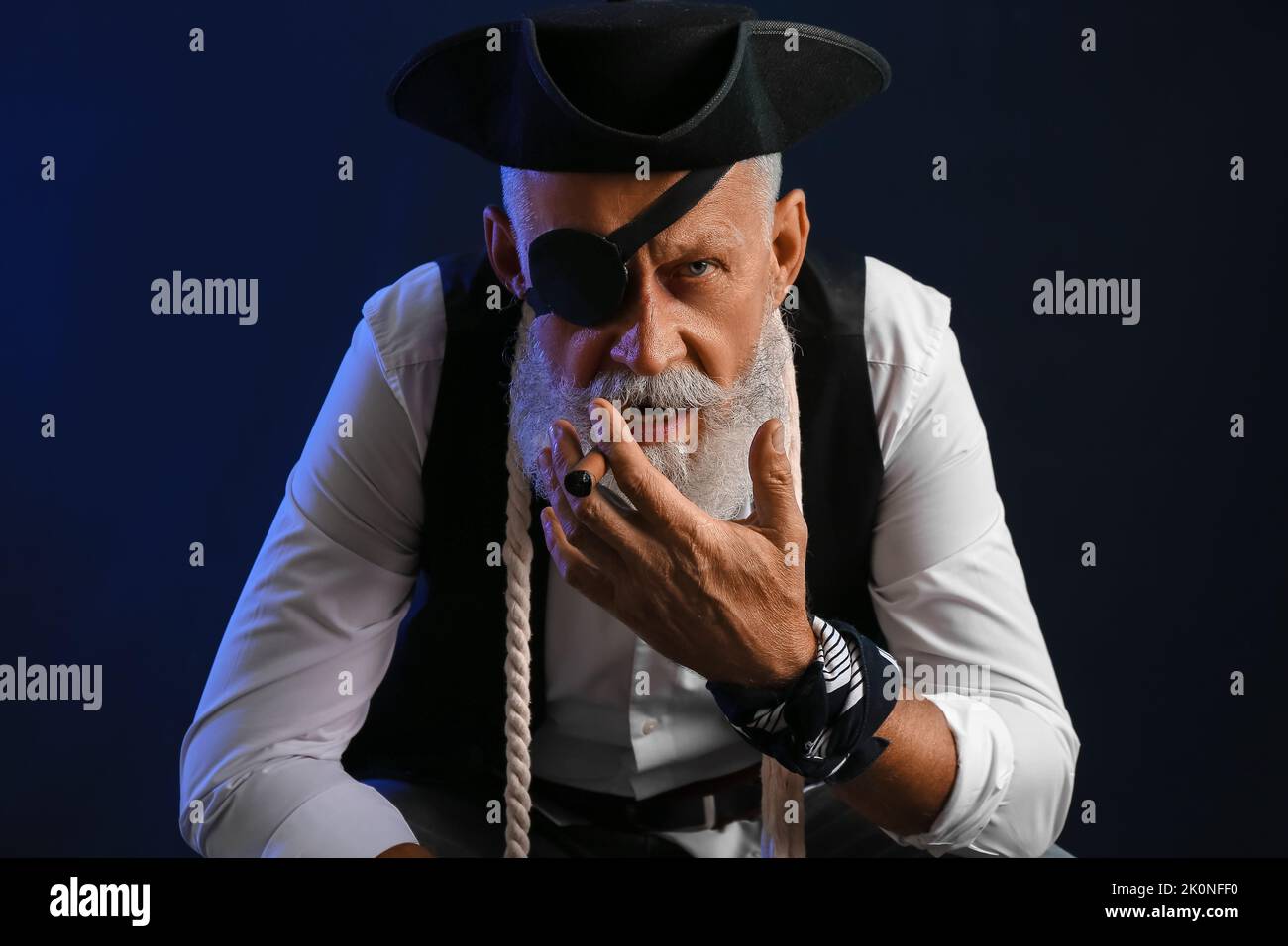 Old pirate smoking cigarette on dark background Stock Photo - Alamy