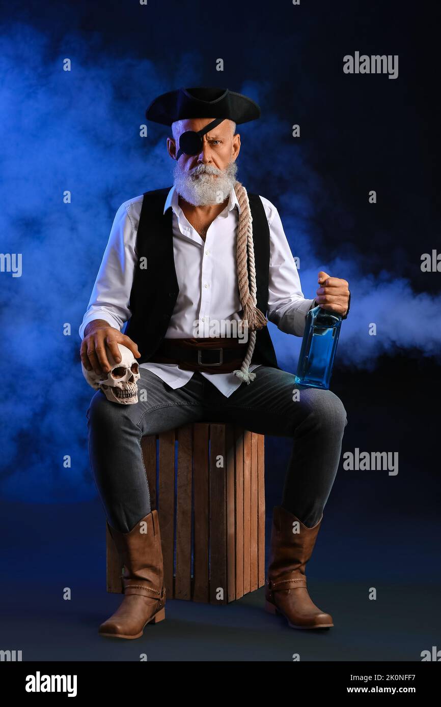 Old pirate with human skull and bottle of rum on dark background Stock ...