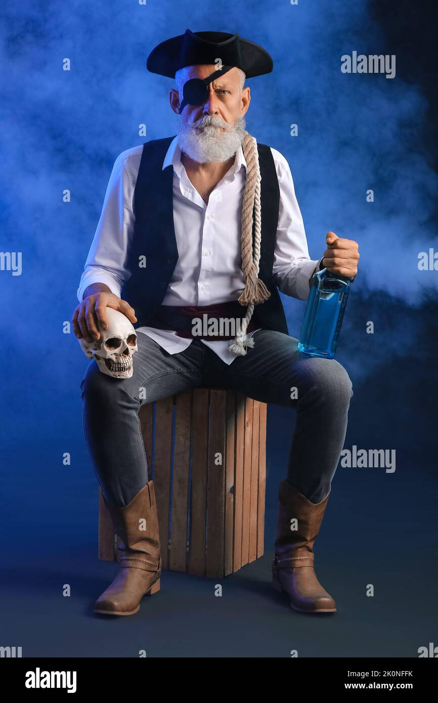 Old pirate with human skull and bottle of rum on dark background Stock ...
