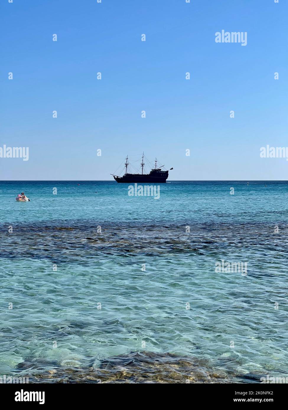 A vertical shot of a ship in a tranquil sea against a blue sky Stock ...