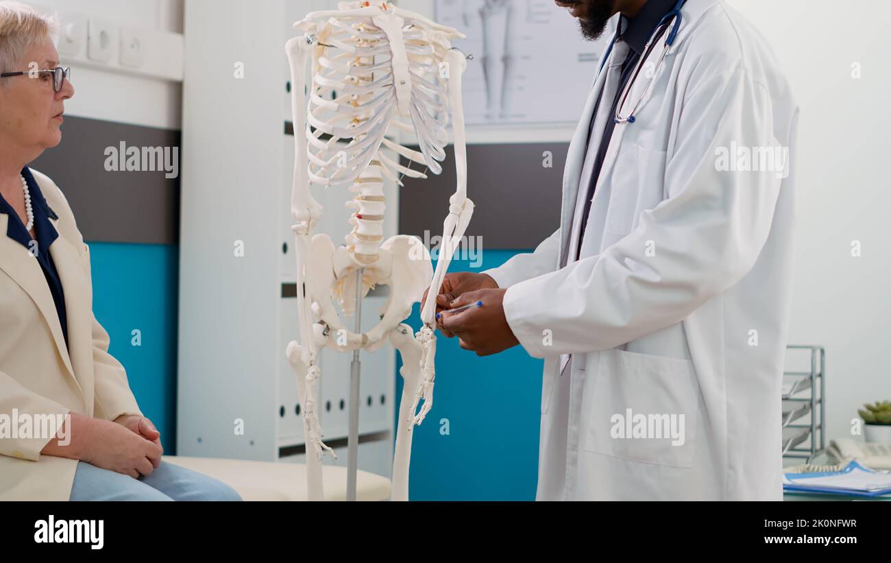 Physician examining human skeleton in cabinet at checkup visit ...
