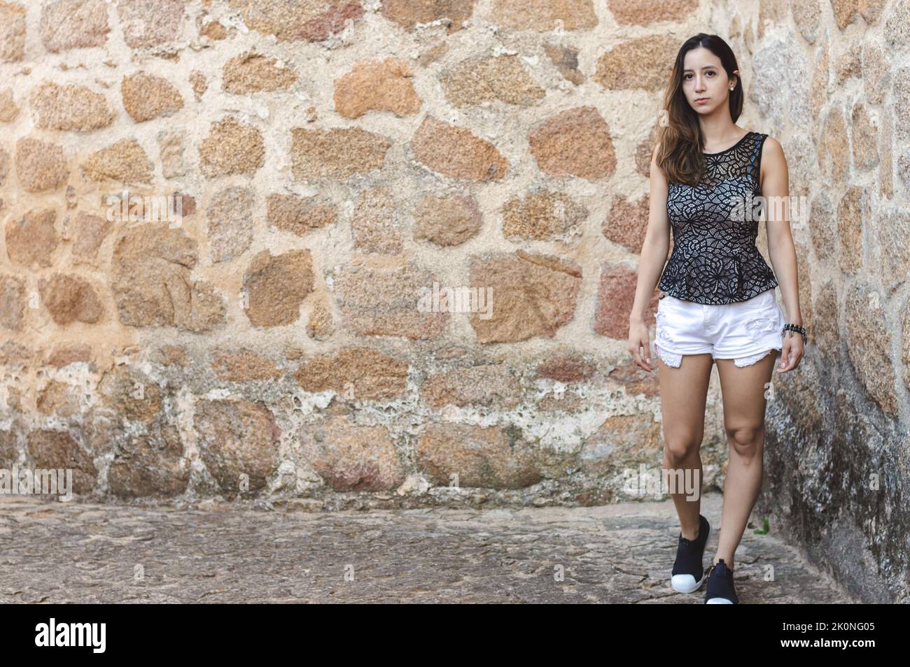 Portrait young attractive woman look at camera serious standing over ...