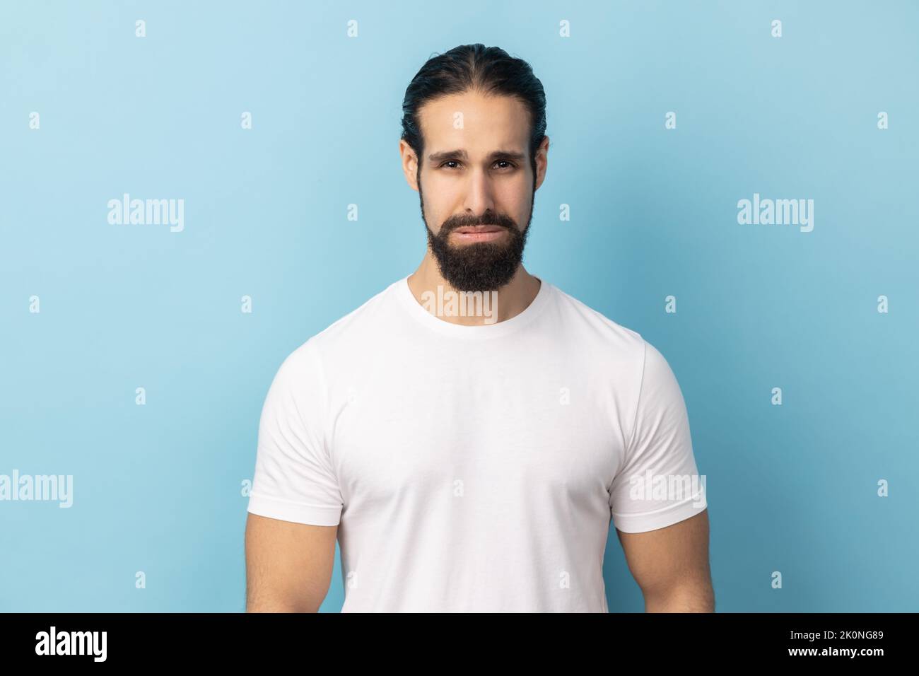 Portrait of man with beard wearing white T-shirt standing and looking ...