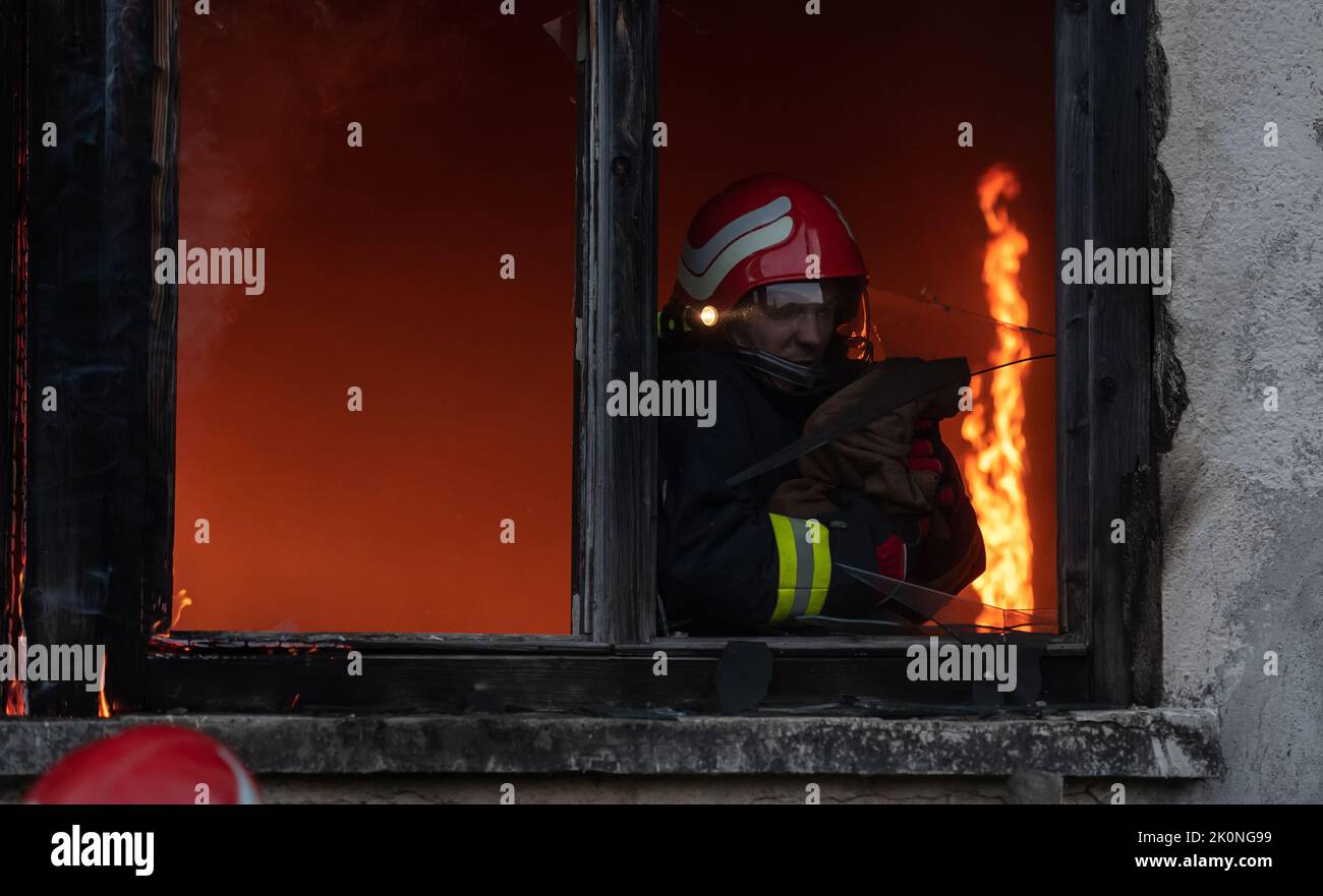 Firefighter hero carrying baby girl out from burning building area from ...