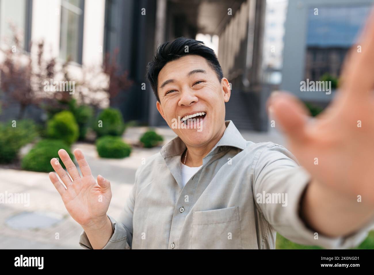 Happy asian man walking waving hi-res stock photography and images - Alamy