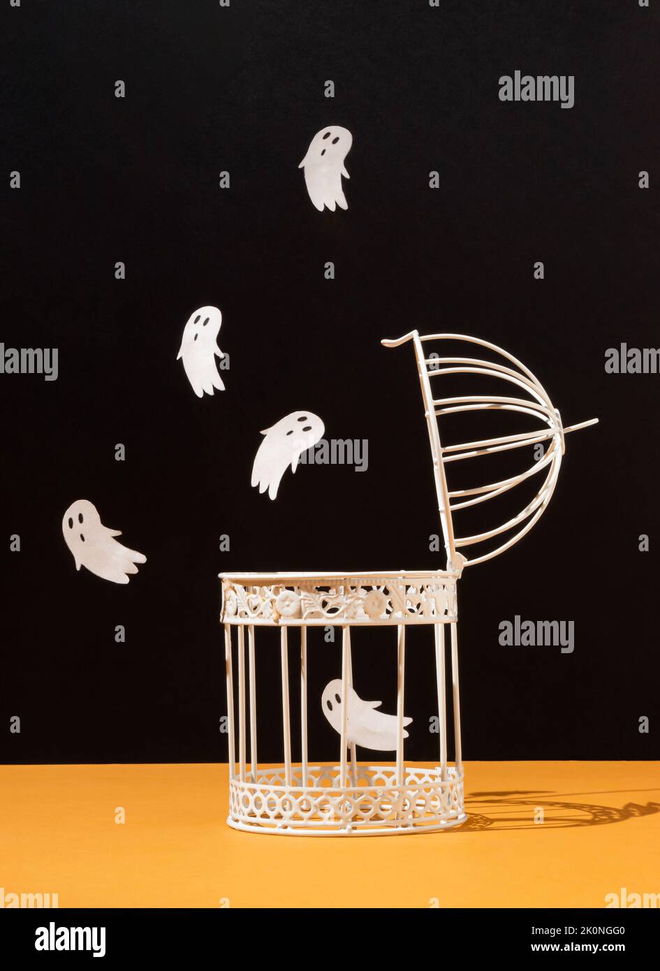 Halloween concept with bird cage and ghosts on black and orange ...