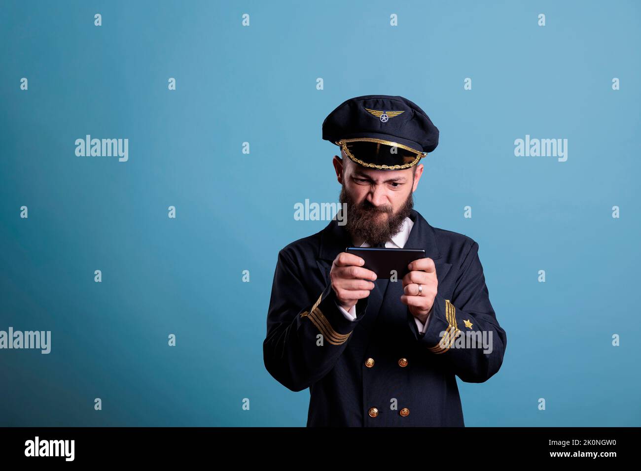 Plane captain in professional uniform playing mobile games on ...