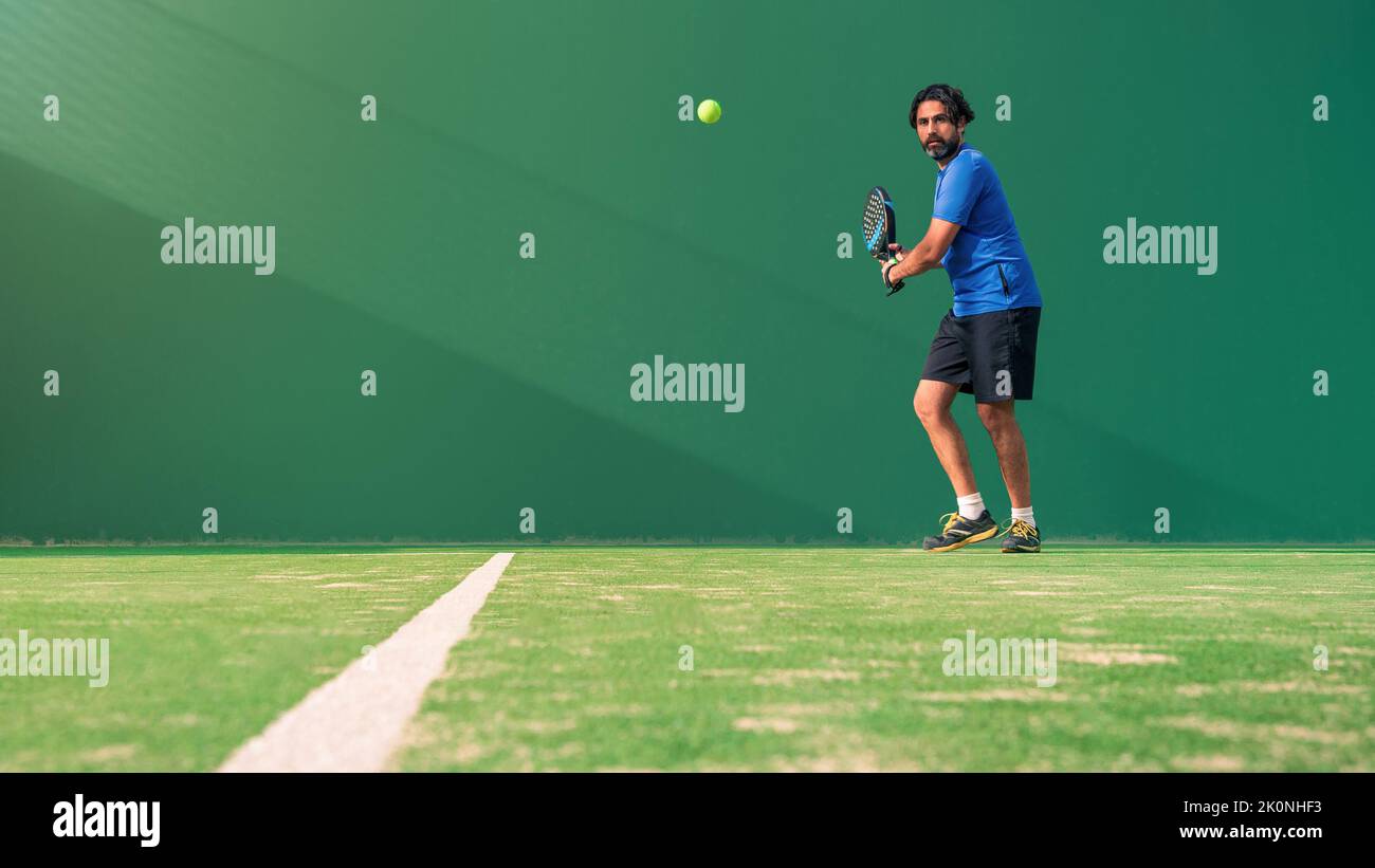 A caucasian padel player jump to the ball, good looking for posts and ...