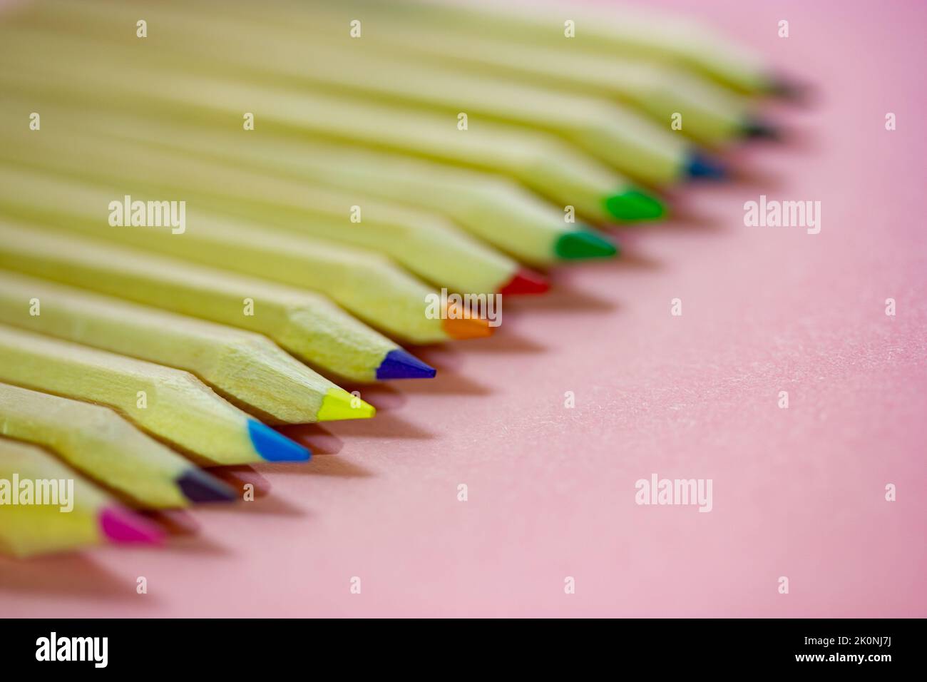 Multicolored wooden pencil rods macro photo on pink table background ...