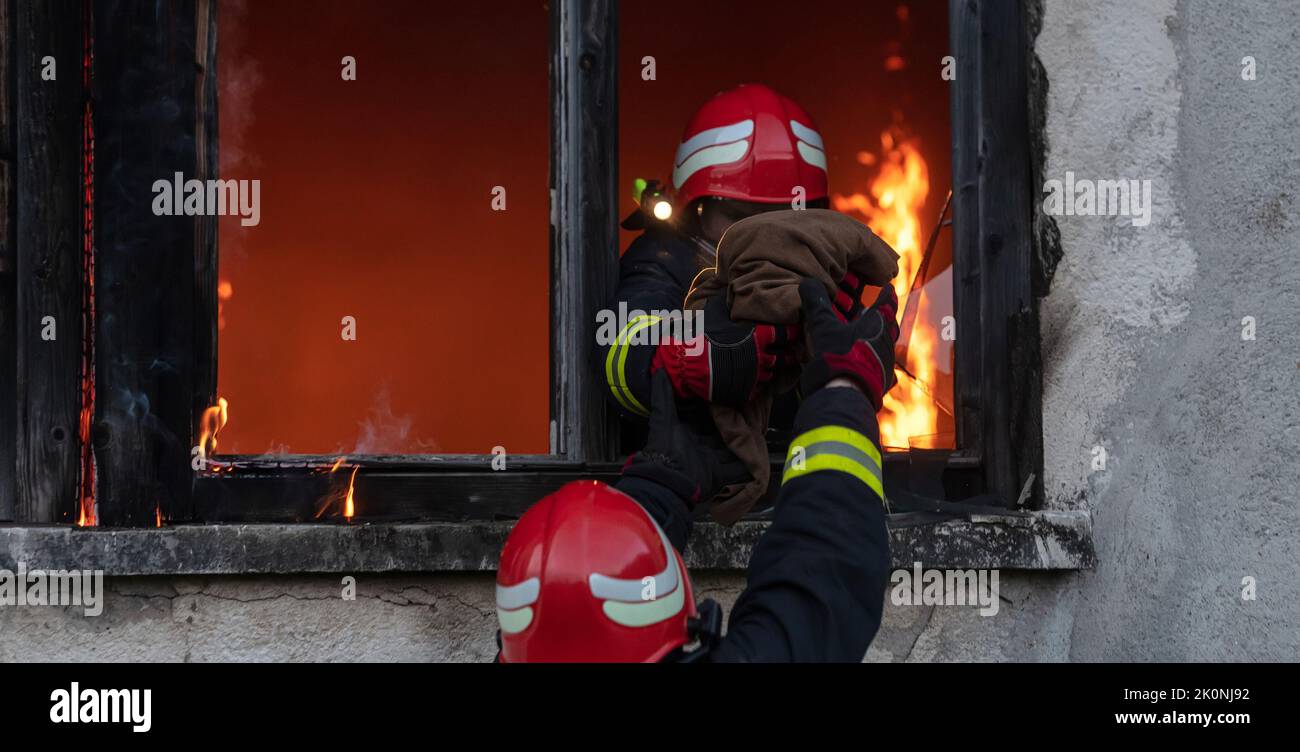 Firefighter hero carrying baby girl out from burning building area from ...