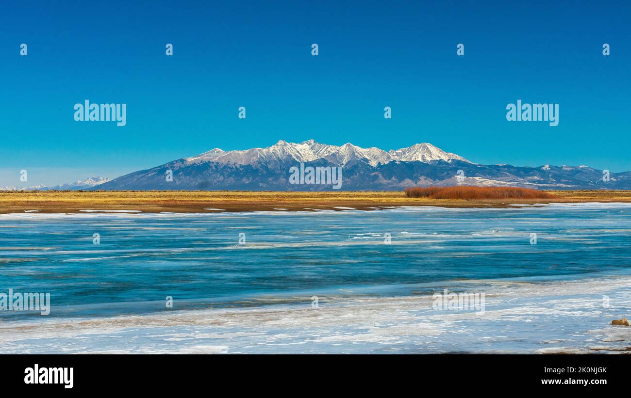 Beautiful snow capped mountains in front of lake in the San Luis Valley ...