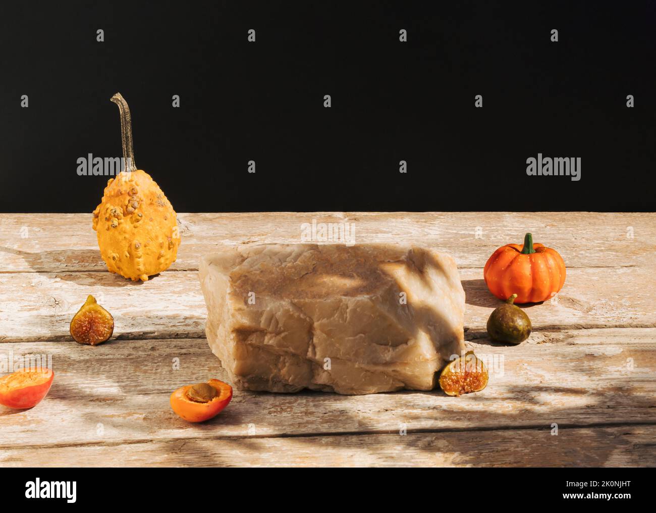 Retro style composition made of gourd, pumpkin, apricots and rock on ...