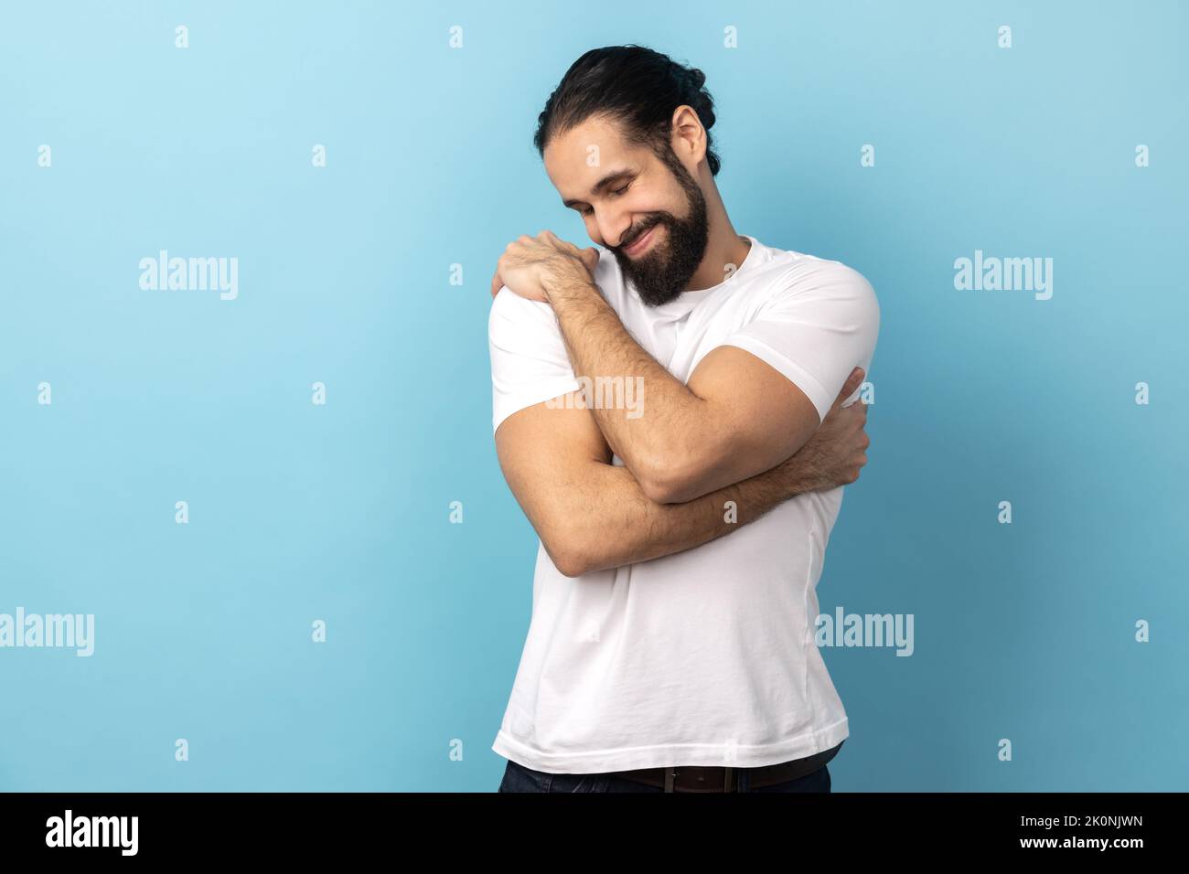 Portrait of happy complacency handsome man with beard wearing white T ...
