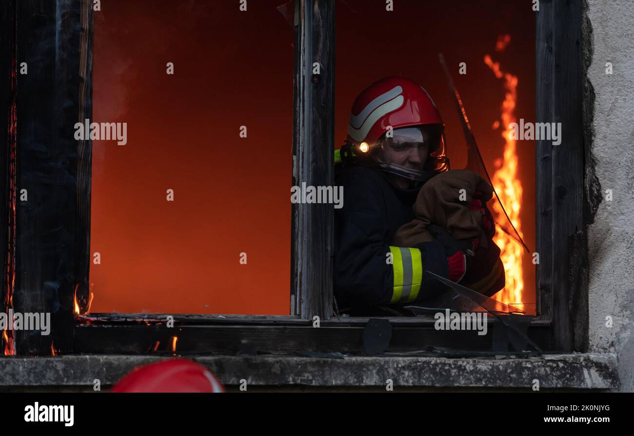 Firefighter hero carrying baby girl out from burning building area from ...