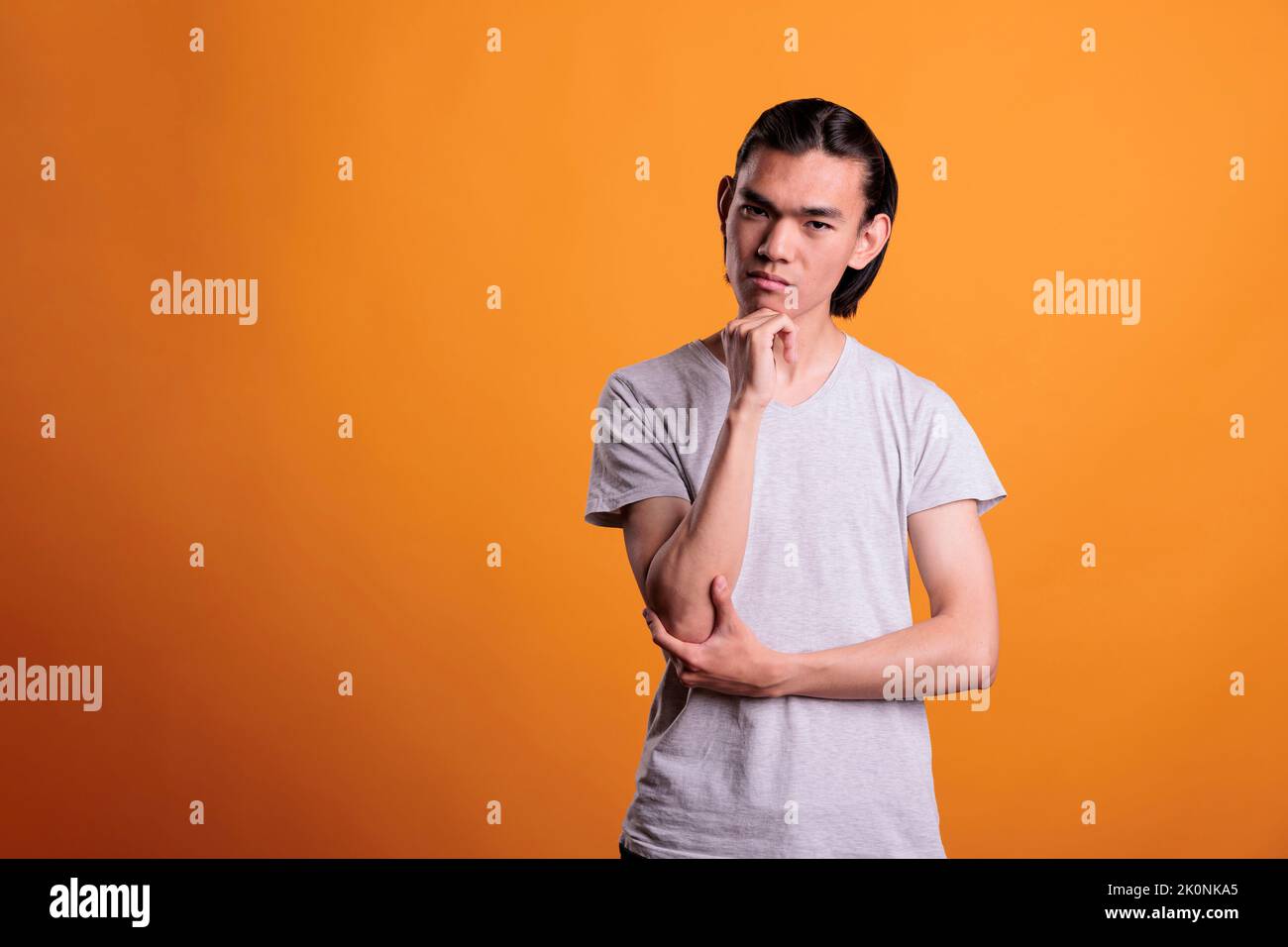 Pensive young man thinking, touching chin with thoughtful facial ...