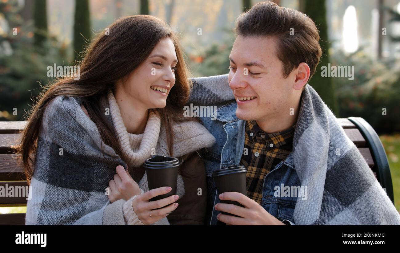 Joyful couple on romantic date in nature park covering with blanket ...