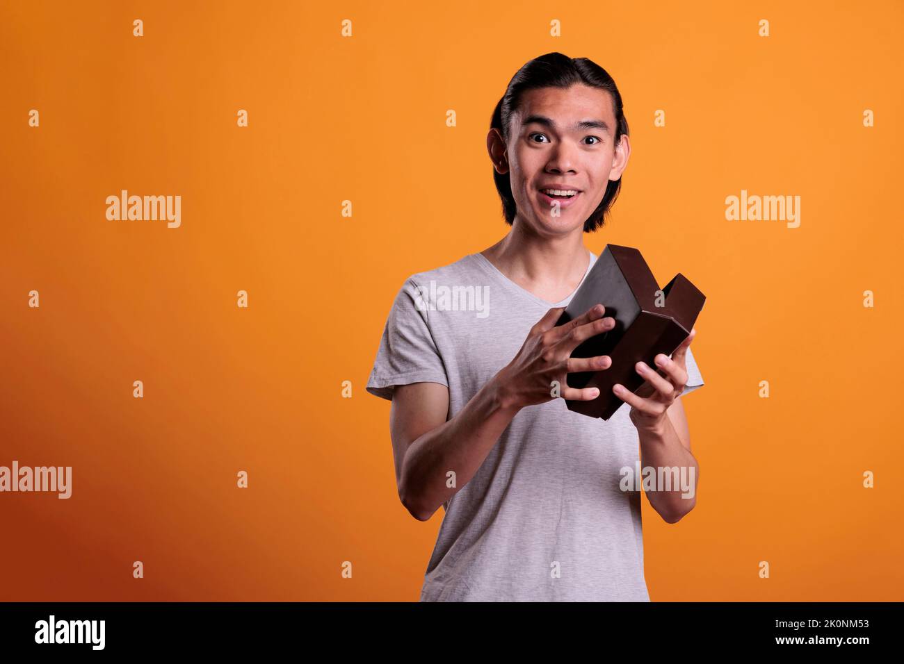 Smiling asian man unboxing package hi-res stock photography and images ...