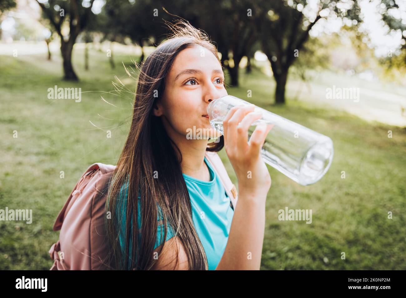 Caucasian young lady wearing turquoise t shirt and a pink backpack ...