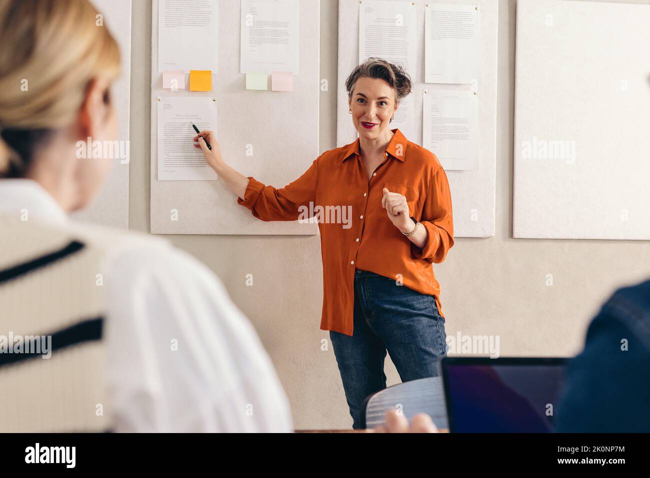 Mature businesswoman giving a presentation to her team during a meeting ...