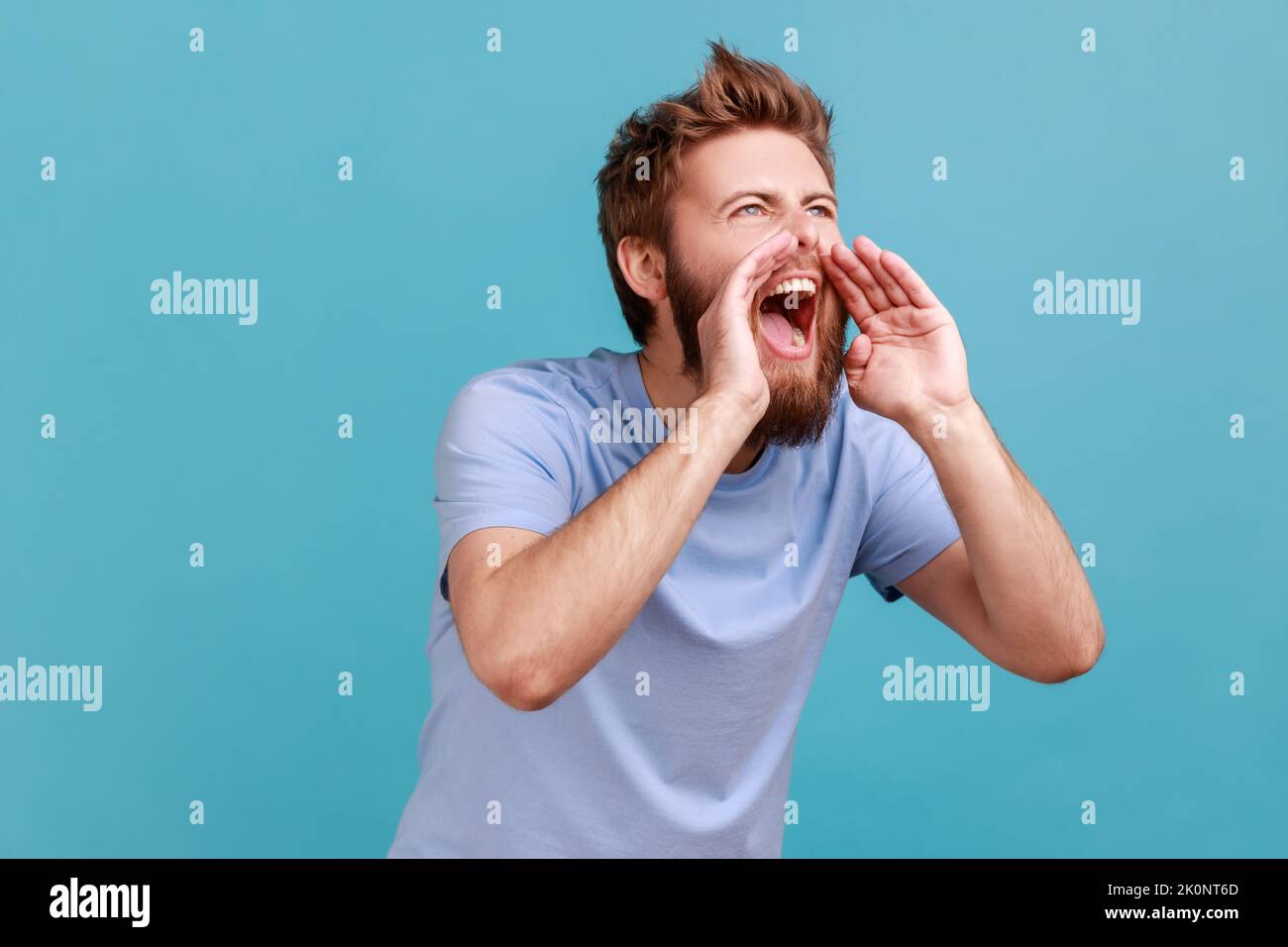 Portrait of angry handsome bearded man loudly screaming widely opening ...