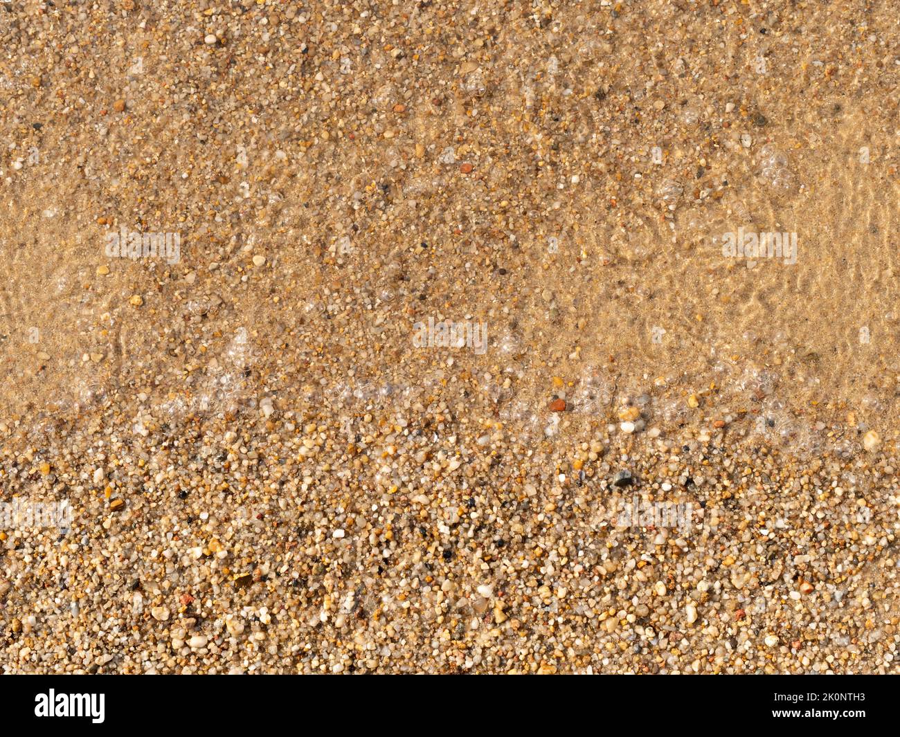 Sand texture on a bathing beach. Clear transparent water with air ...
