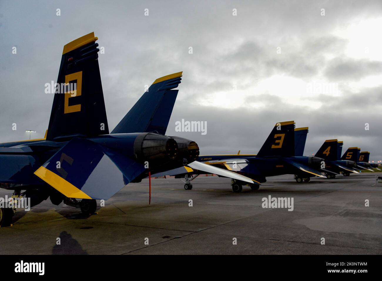 A row of Blue Angels performance aircraft rest on the flightline here ...