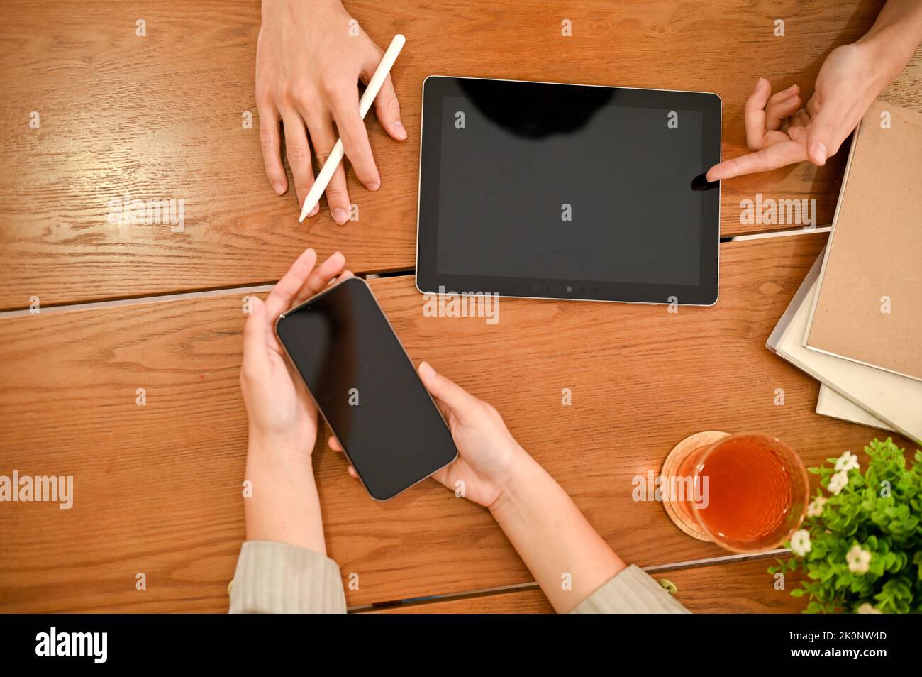 Overhead shot, Two female friends working together, using smartphone ...
