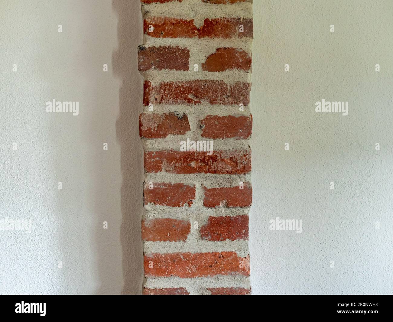 Red brick stone post inside in a room. Old masonry as part of the ...