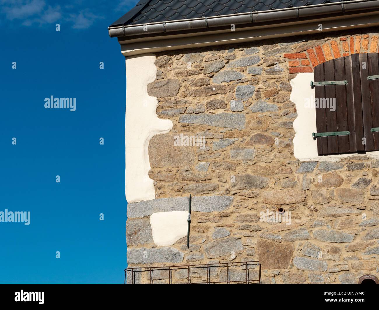 Wall of a country house with old stones. Renovated facade of a building ...