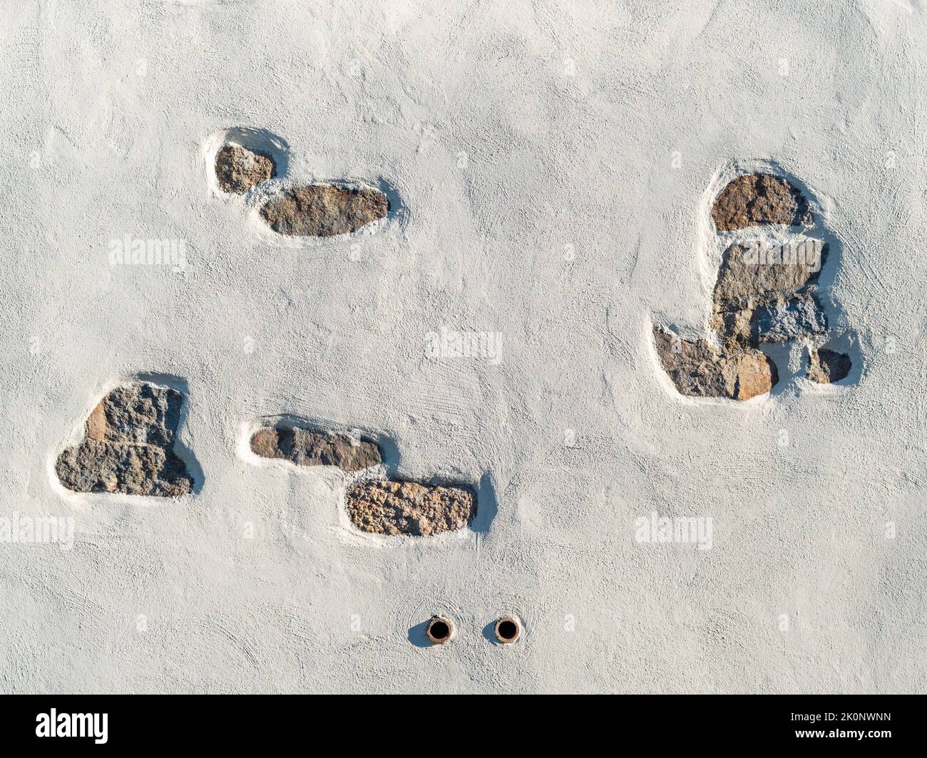 Old facade with gaps in the white wall plaster. Natural stones are ...