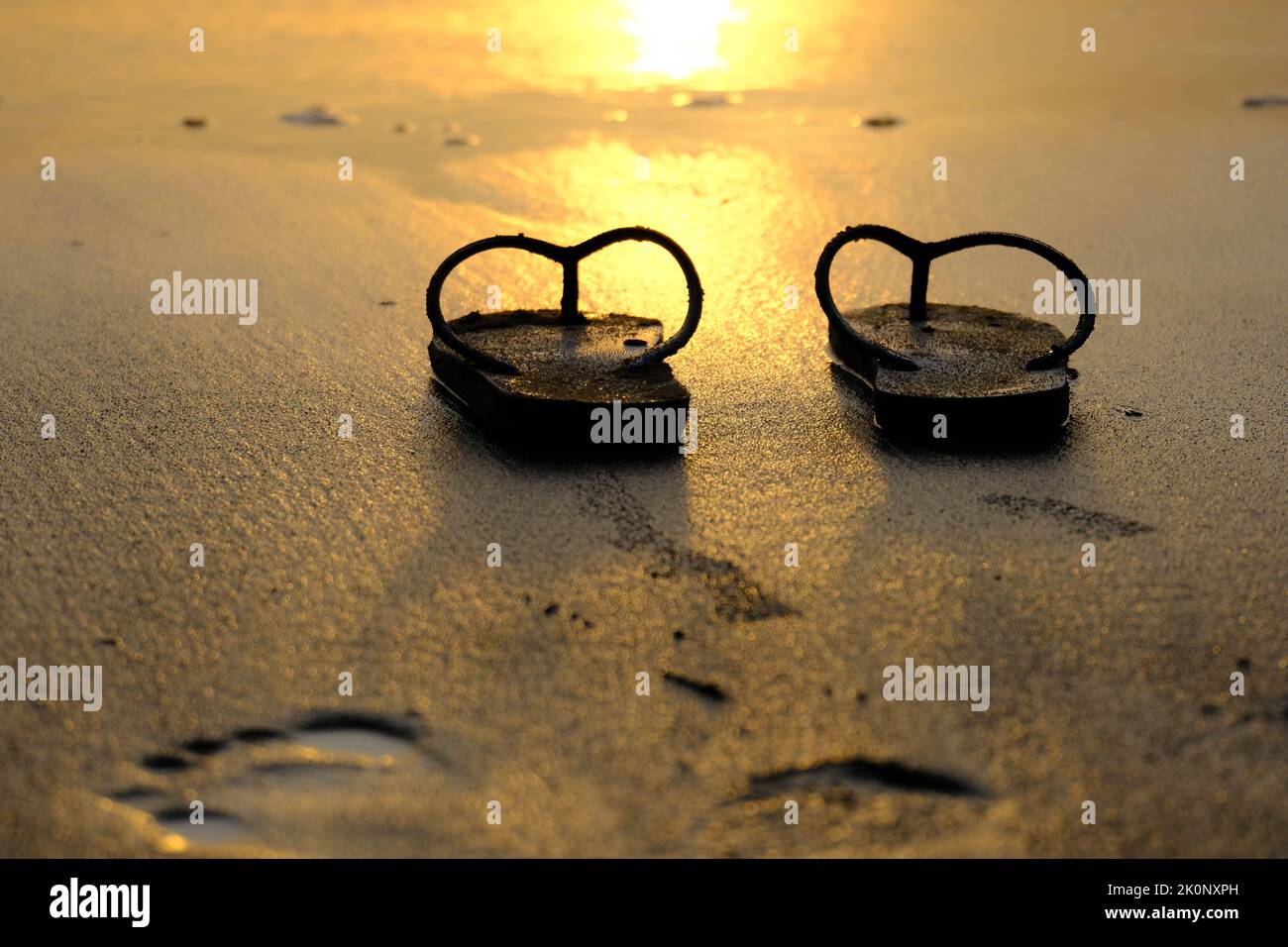 Sandals on the beach on a beautiful background of the beach at sunset ...