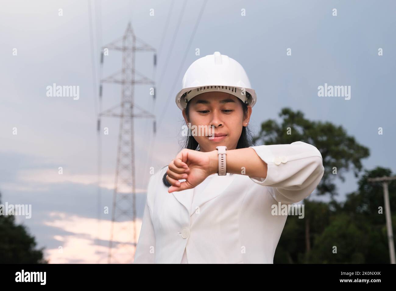 Asian female electrical engineer looking at a smart watch on the ...