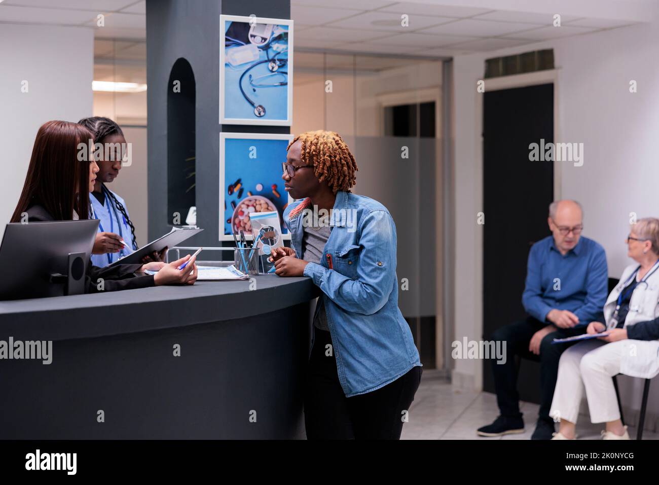 African american patient signing checkup files at hospital reception ...