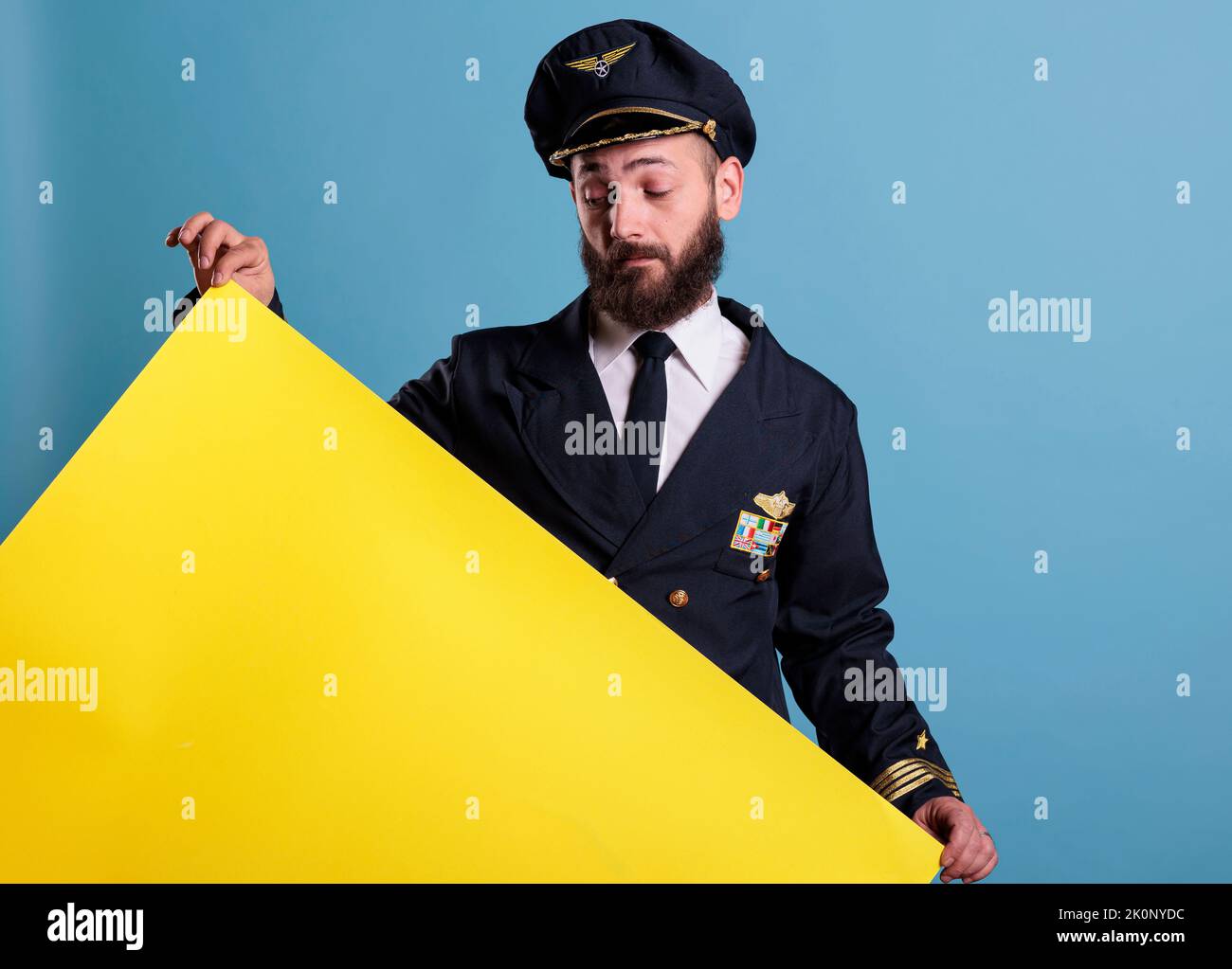 Airplane pilot holding yellow empty advertising banner with copy space ...