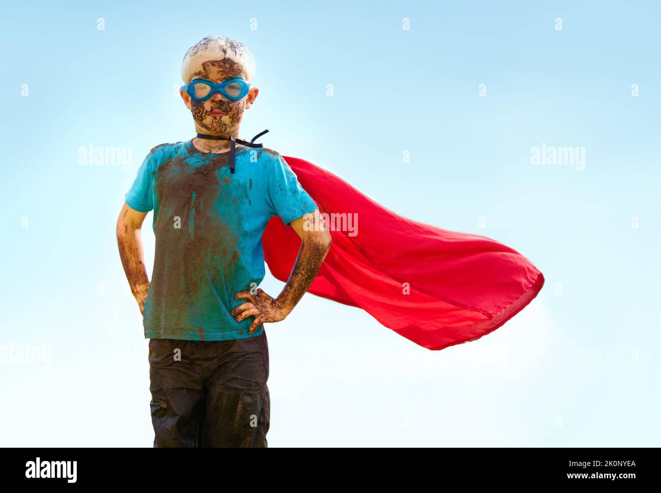 A muddy superhero. A little boy dressed as a superhero and covered in ...