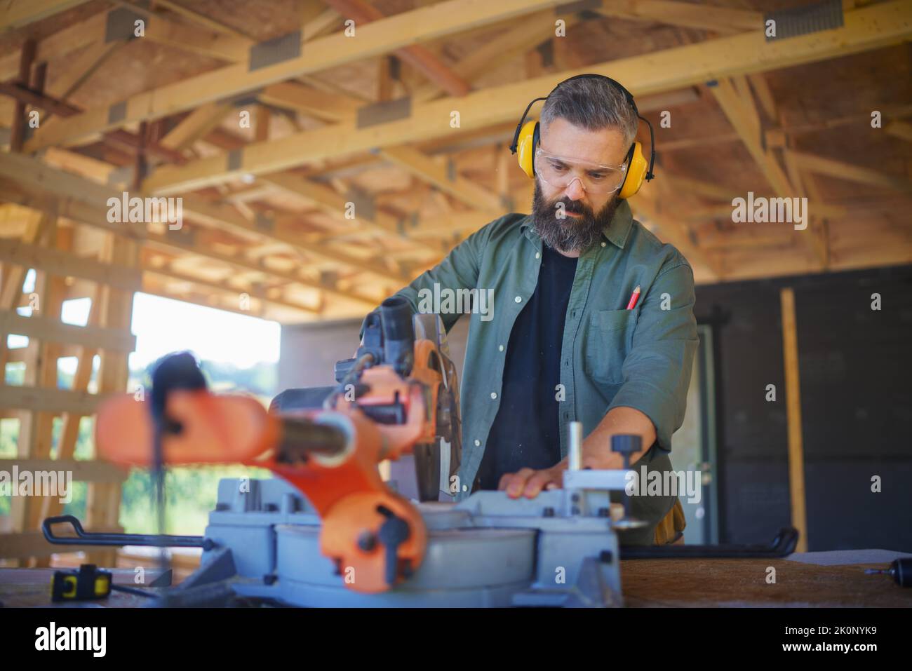 Construction worker working with eletric saw inside wooden construction ...