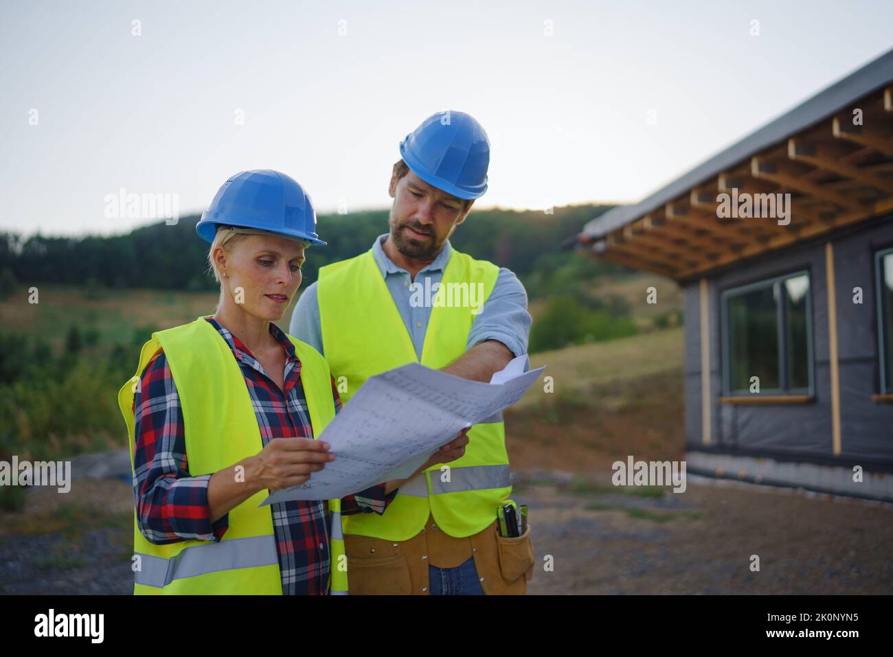 Construction engineers or architects checking blueprints in front of ...