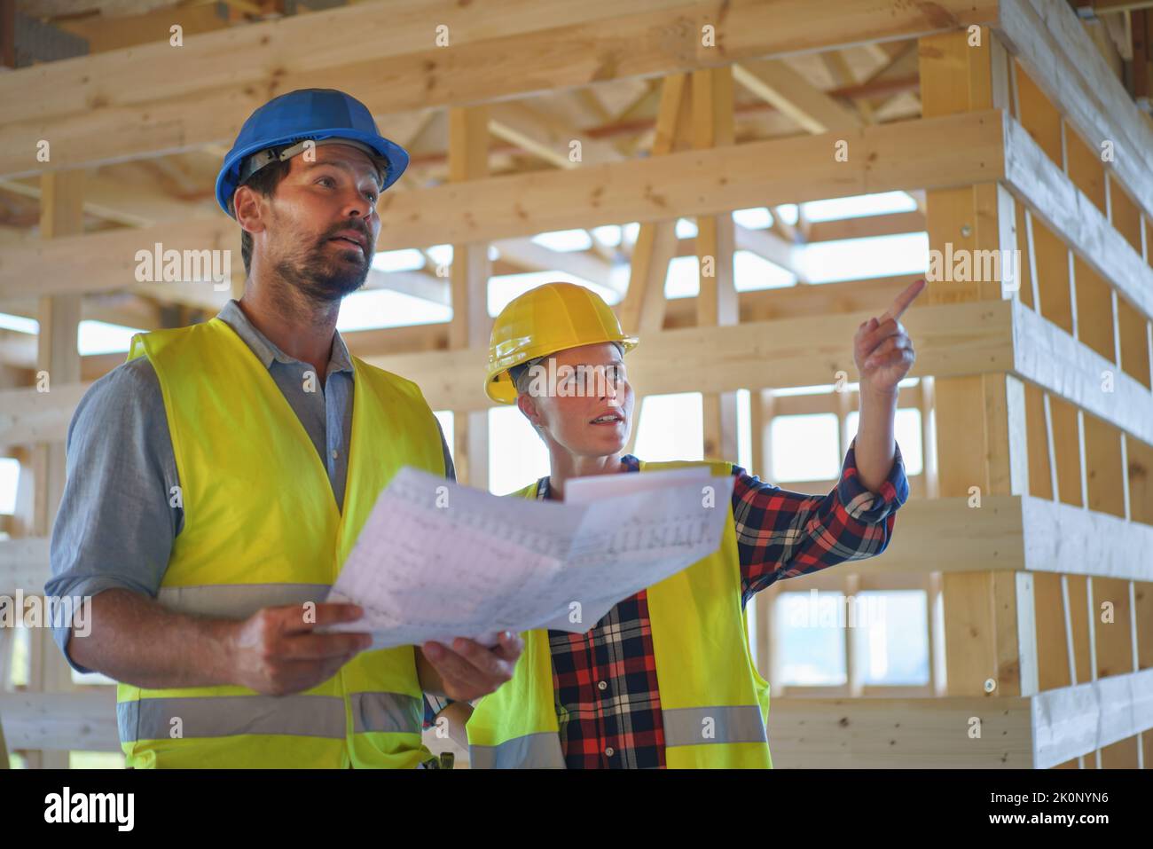 Construction engineers or architects with blueprints checking eco ...